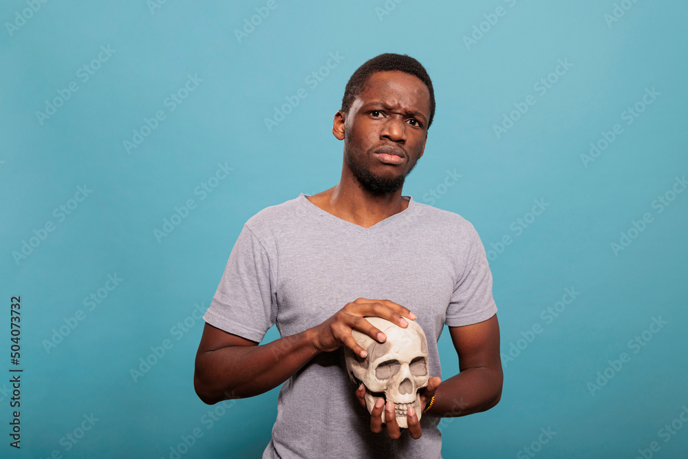 Millennial person holding human body skull from skeleton to study ...