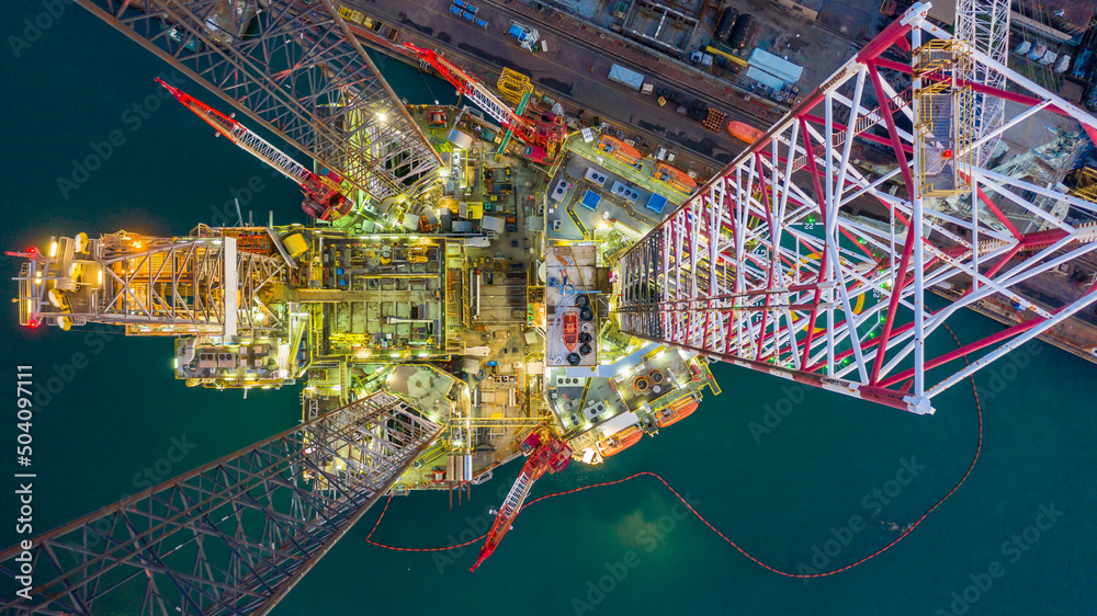 Aerial top view jack up rig under maintenance at night with blue ocean ...