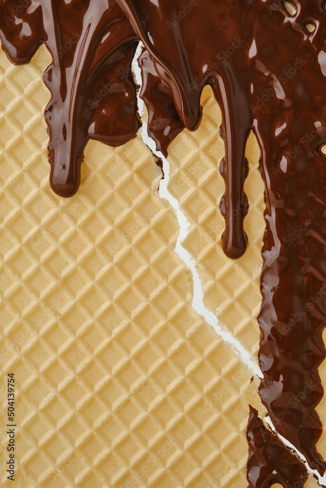 Streams of molten chocolate flowing down a waffle sheet. Close up of ...