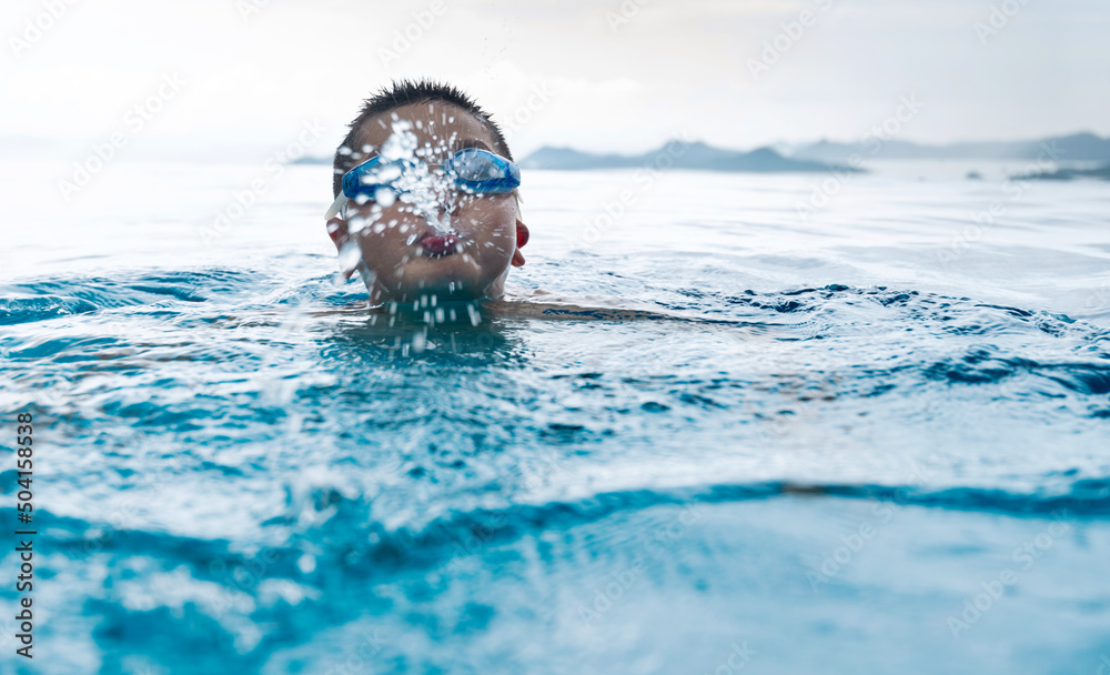 Boy swimming and spitting water from mouth Stock Photo | Adobe Stock