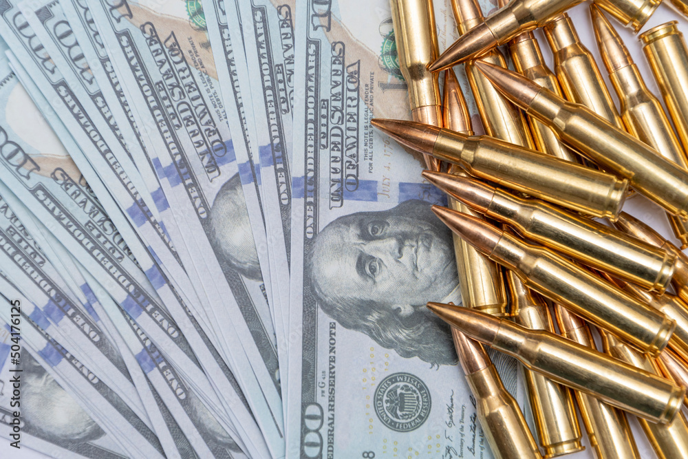 Scattered cartridges with bullets on 100 dollar bills, close-up ...