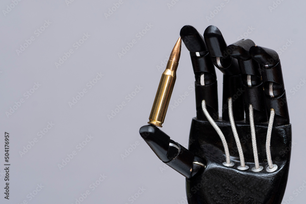 The black mechanical arm of the robot holds a cartridge with a bullet ...