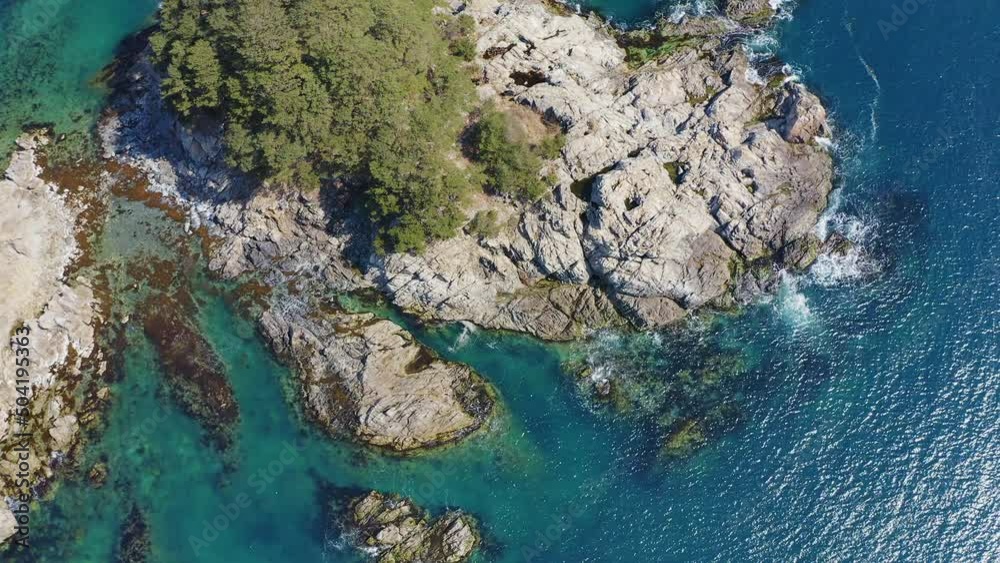 A beautiful rocky island covered with coniferous trees connected to the ...