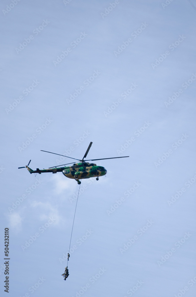 Army exercise with soldiers hanging on a cable from a Mi-17 helicopter ...