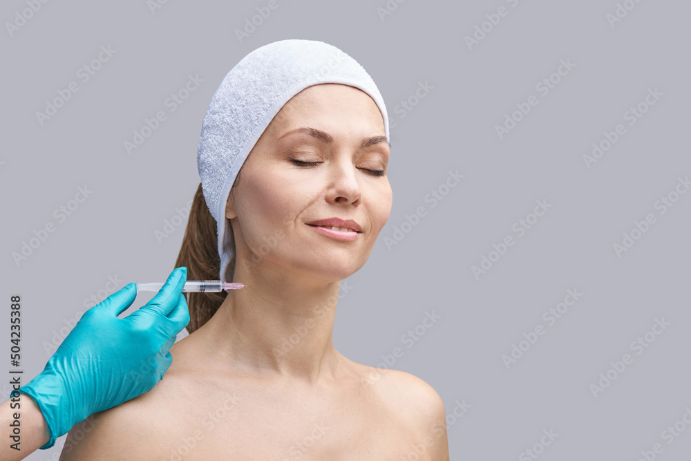 Face needle injection. Young woman cosmetology procedure. Doctor hand ...