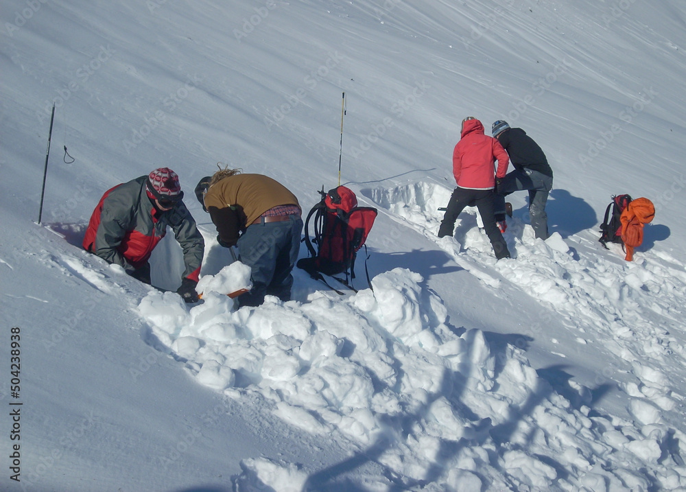 Avalanche safety students digging snow pits to test slope stability ...