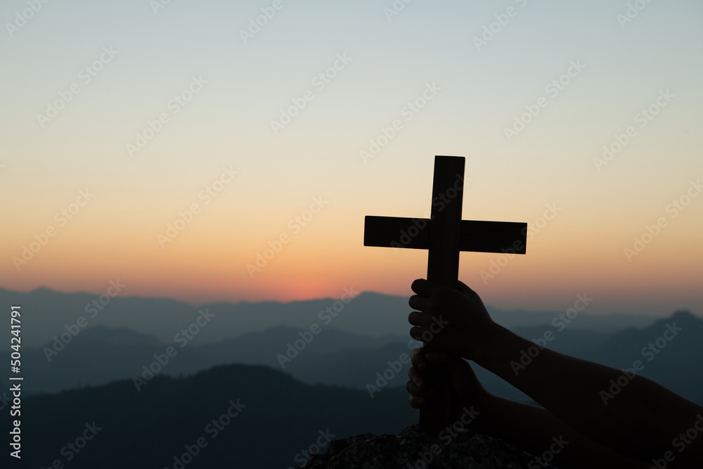 Close up man hand holding wood cross or religion symbol shape over a ...