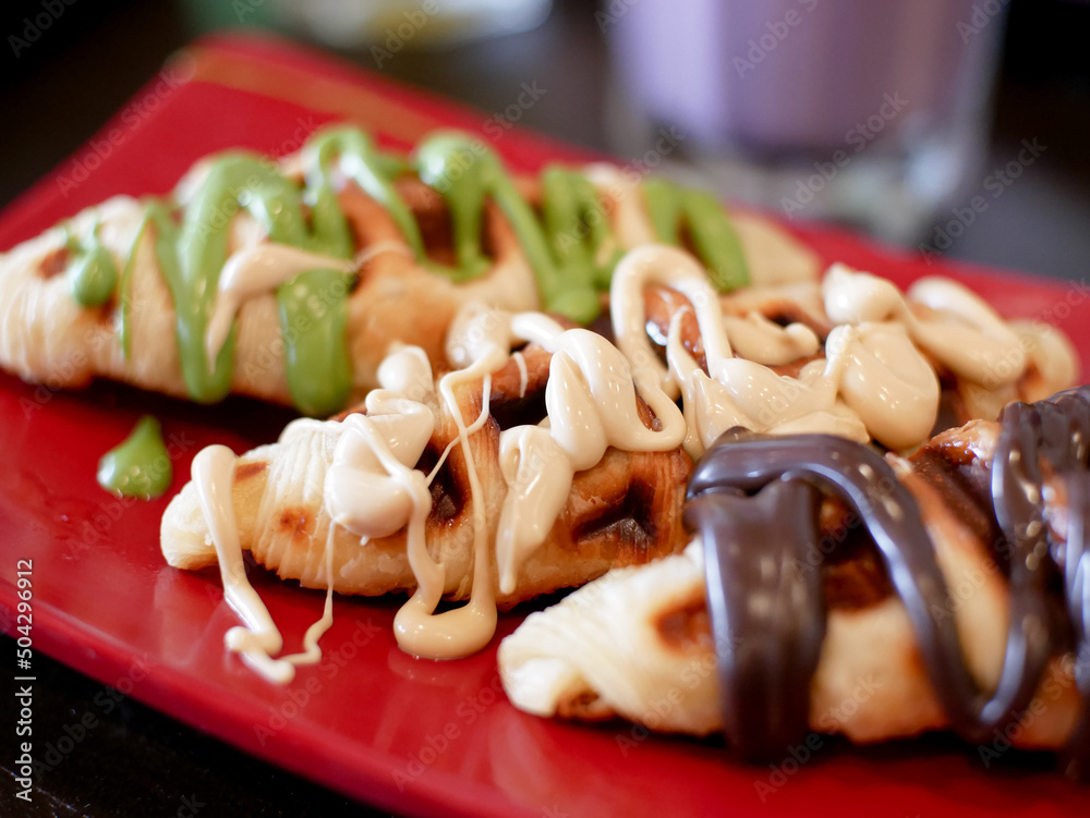 croffles on a red plate with lots of flavors and toppings Stock Photo ...