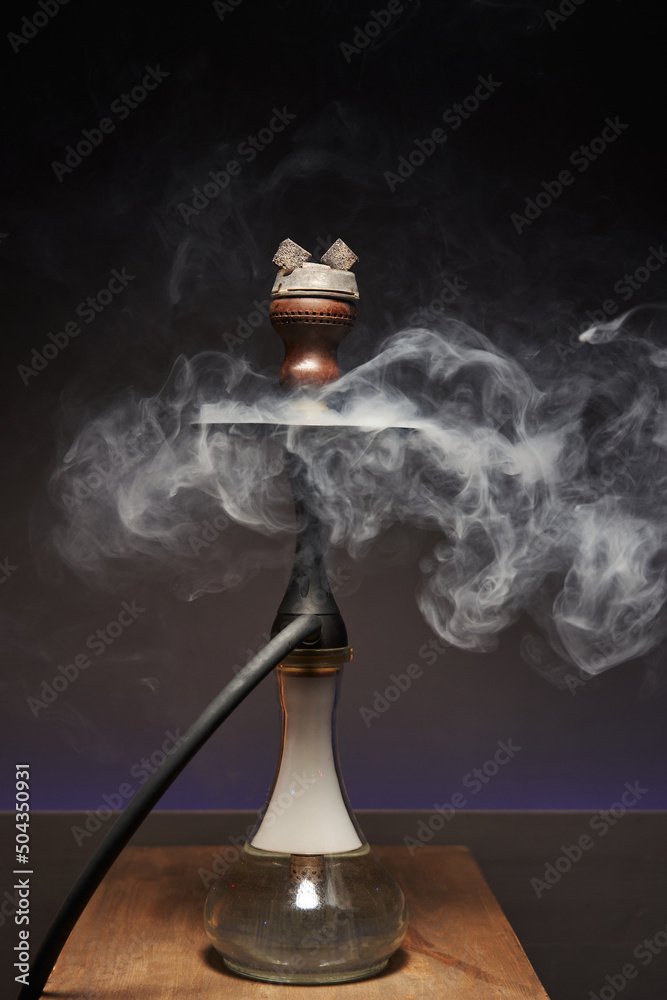 beautiful hookah shrouded in white smoke with a transparent flask in ...