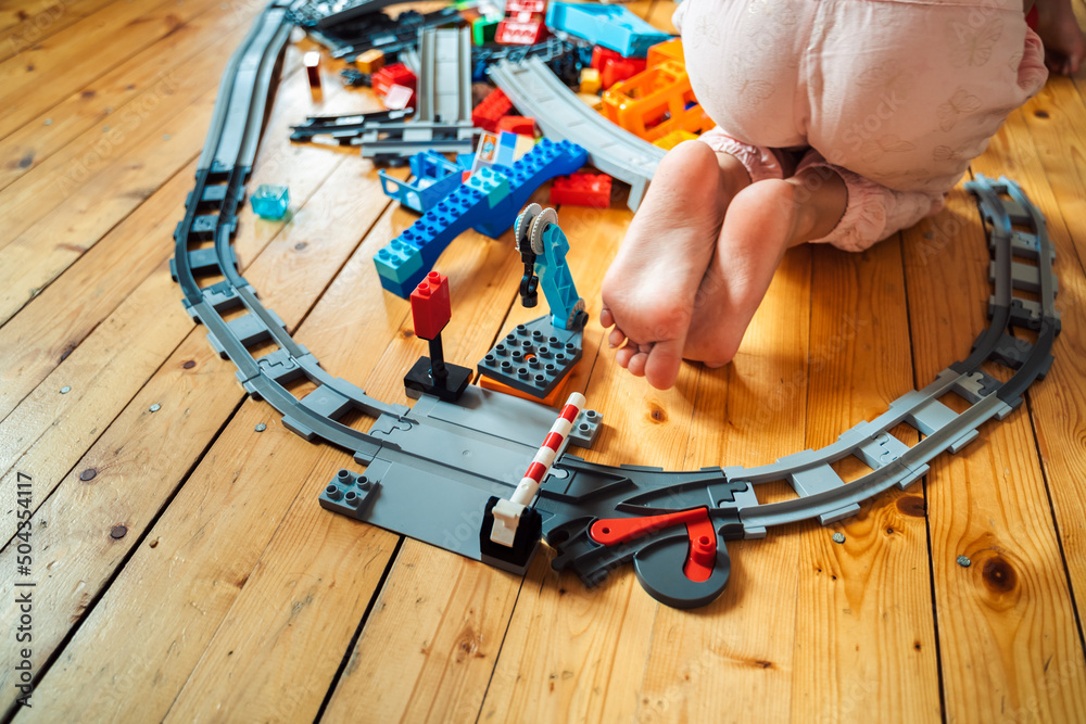 Girls, sisters play kids constructor, build toy railway, railroad by ...