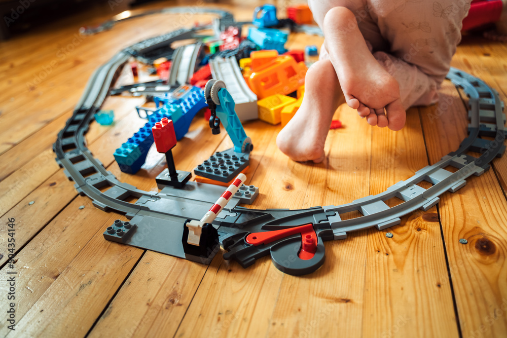 Girls, sisters play kids constructor, build toy railway, railroad by ...