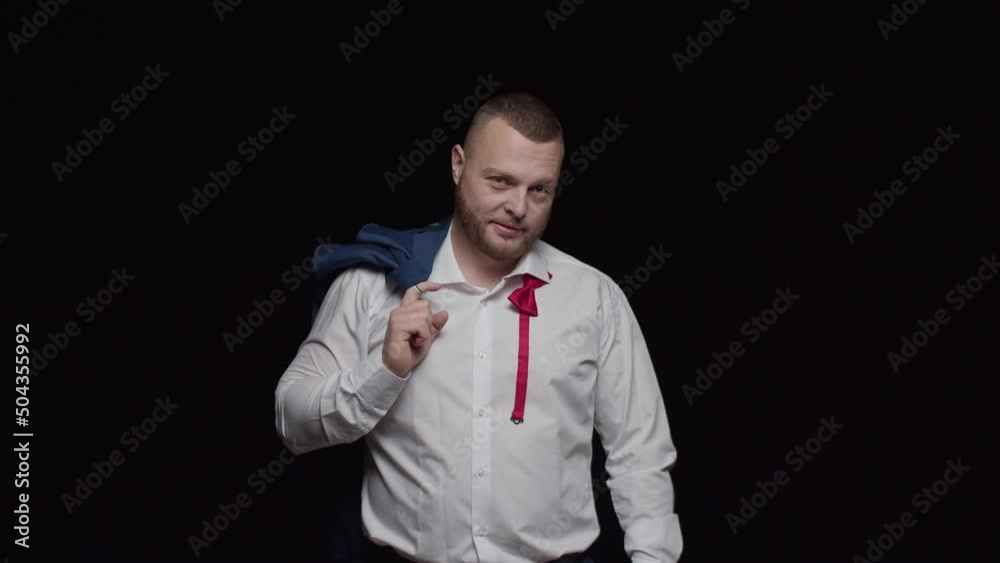 A man with a beard in a white shirt with a red bow tie unbuttoned and a ...