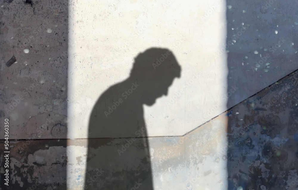 The silhouette of a desperate man, sad and surrendering, projected by ...