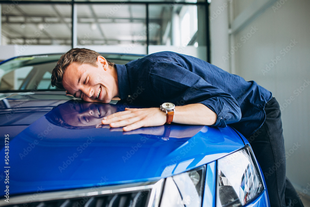 Man hugging a car in a car showroom Stock Photo | Adobe Stock