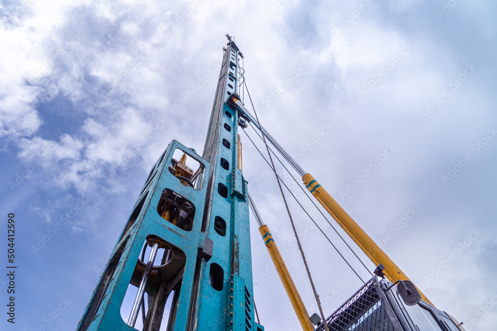 lifting boom of a piling machine going up into the sky, bottom view ...
