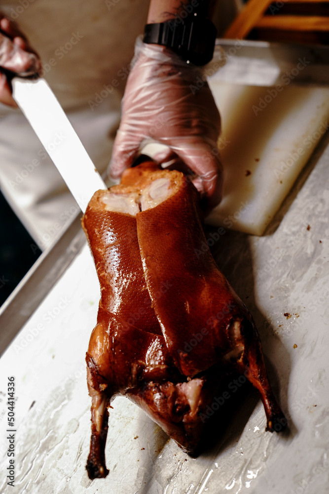 Chinese cook prepares Peking Roast Duck. Peking Duck is a famous duck ...