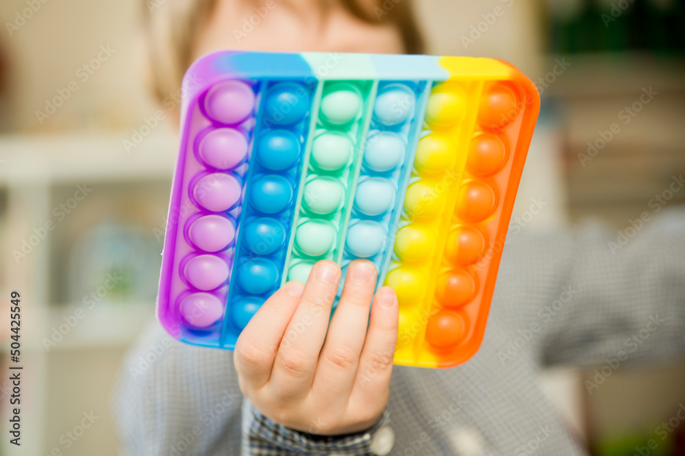 Child plays with sensory fidget toy Pop-it. Instrument for fine motoric ...