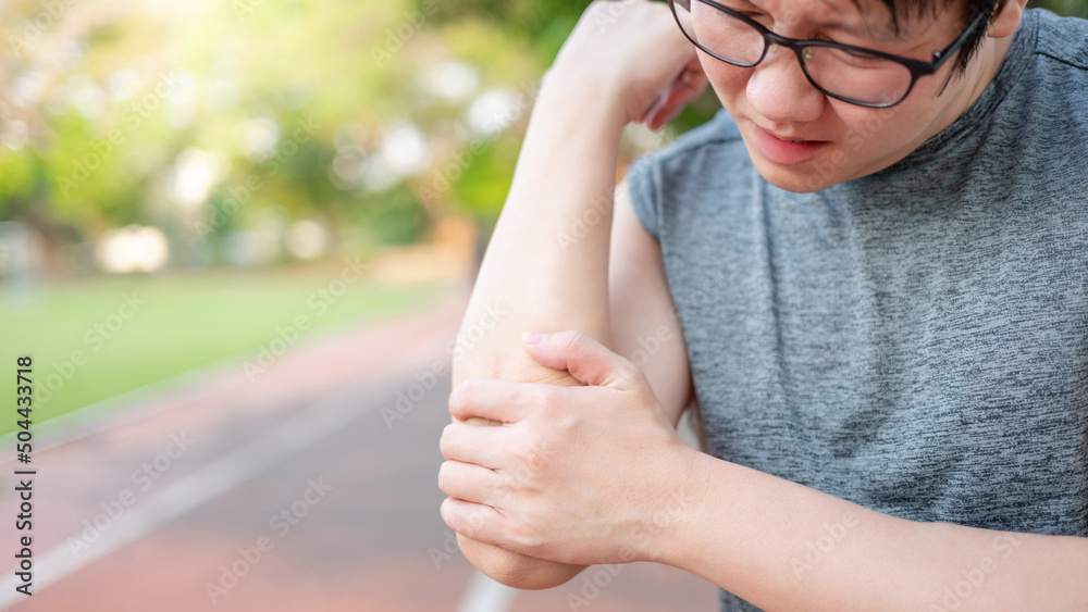 Asian athlete man suffering from elbow and lower arm pain while doing ...