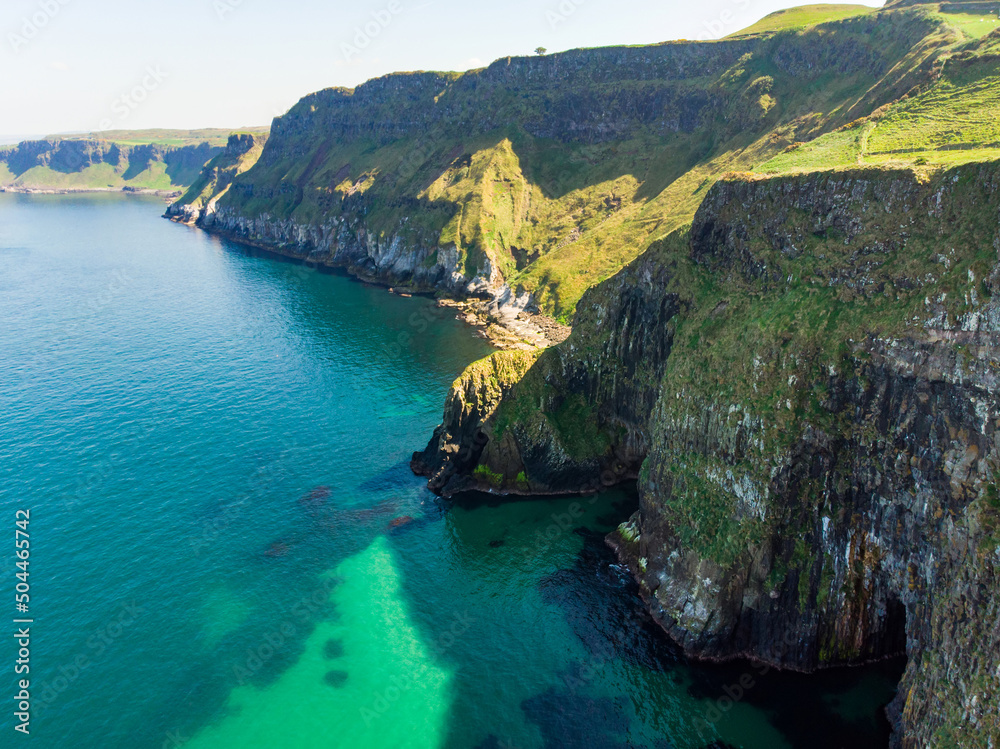 Vivid emerald-green water at Ballintoy harbour along the Causeway Coast ...