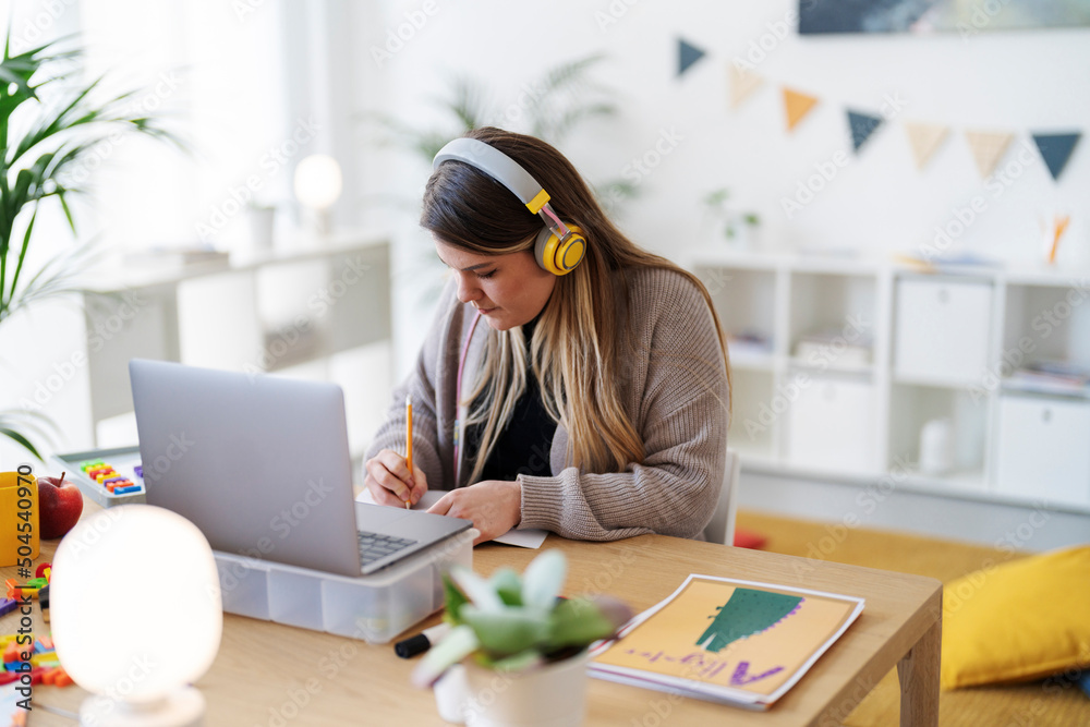 Teacher taking notes during remote lesson Stock Photo | Adobe Stock