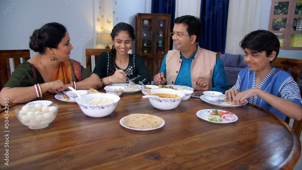 A modern Bengali couple and their little kids having lunch / dinner ...
