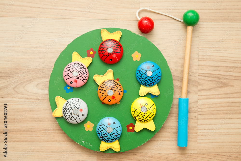 Let's go fishing. Wooden fishes and fishing rod with magnet on the tip ...