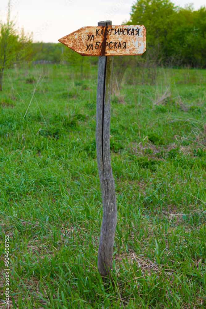A funny homemade sign was made from a log and a board with a marker ...