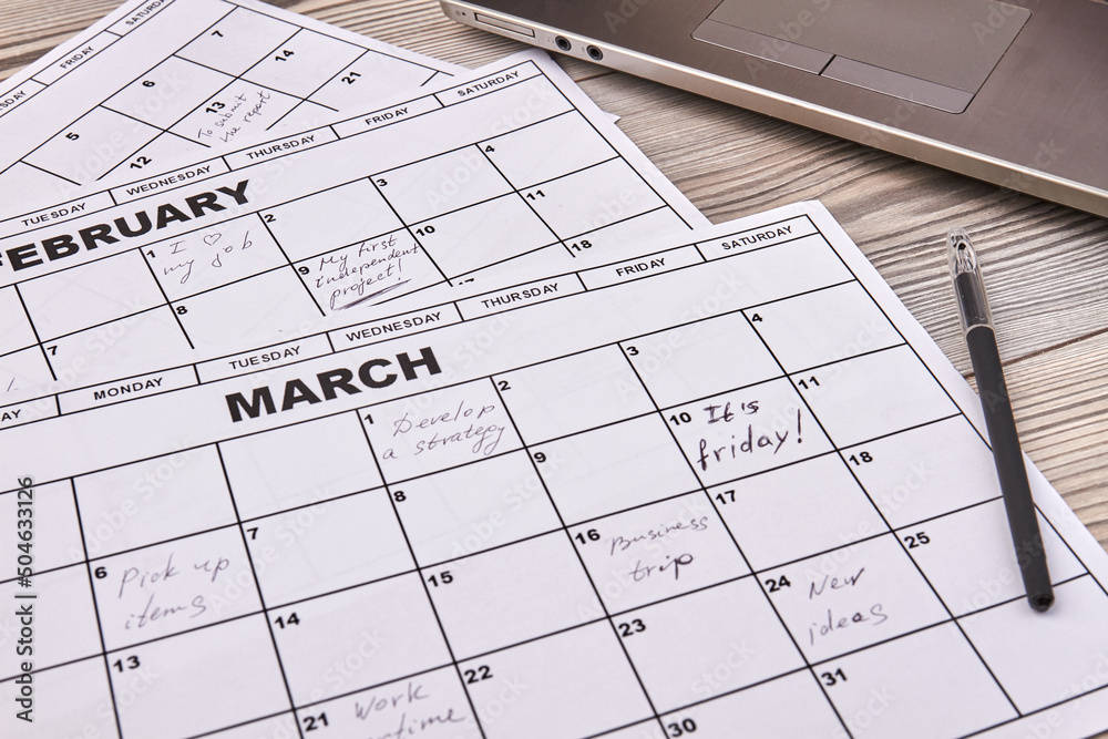 Paper month calendar with pen and laptop. White desk background. Stock ...