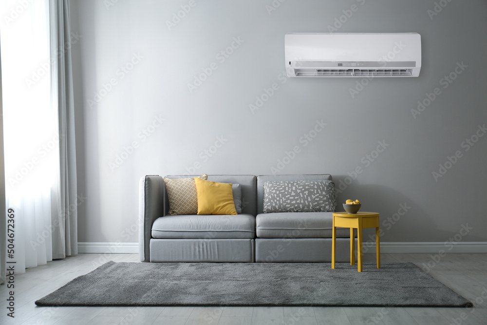 Modern air conditioner on light grey wall in living room with stylish ...