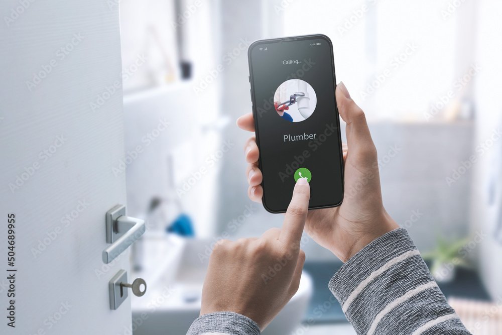 Woman calling a plumber on her smartphone Stock Photo | Adobe Stock
