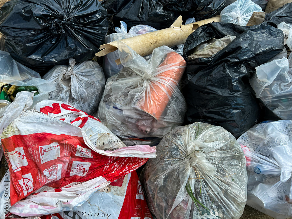 Human garbage in plastic bags near roadside, conceptual image of human ...