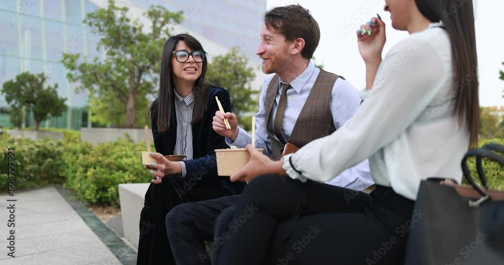 Diverse business people doing lunch break outdoor from office building ...