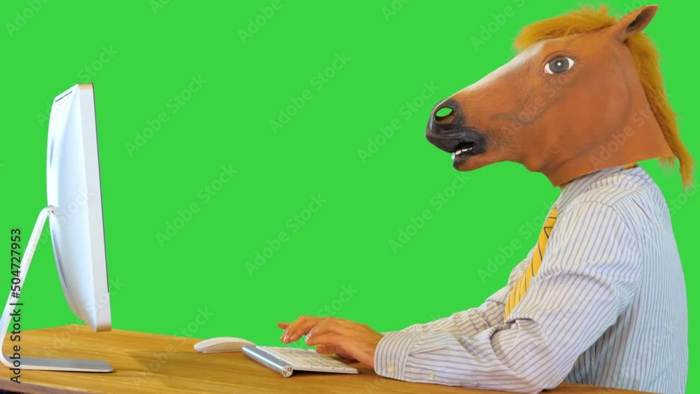 Formal office worker in funny horse mask work on computer using modern ...