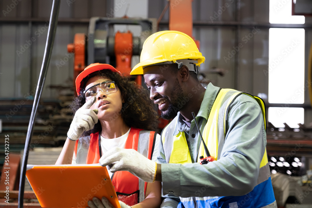 African mechanical engineer team, wearing safety equipment. While doing ...