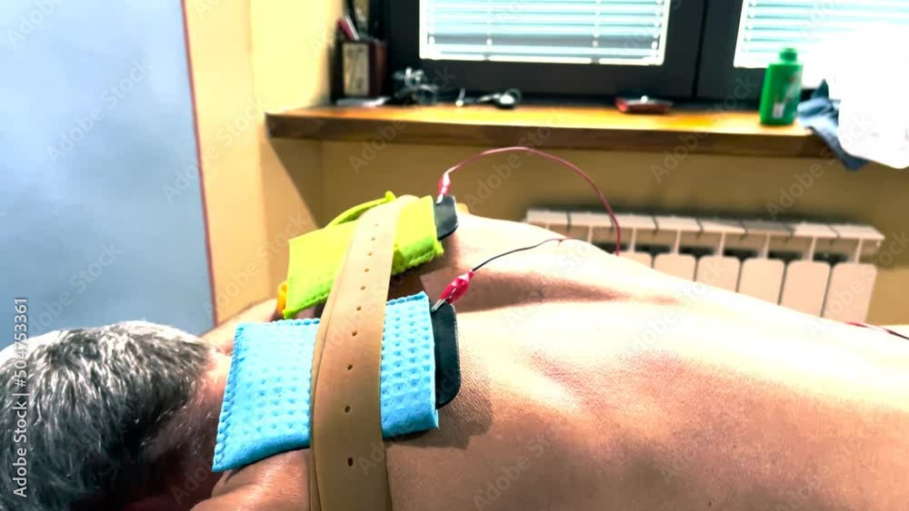 Muscle stimulator device with electrodes applied to biceps and ...