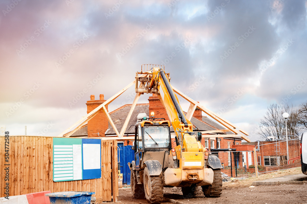 Telehandler moving roof trusses on new housing development building ...