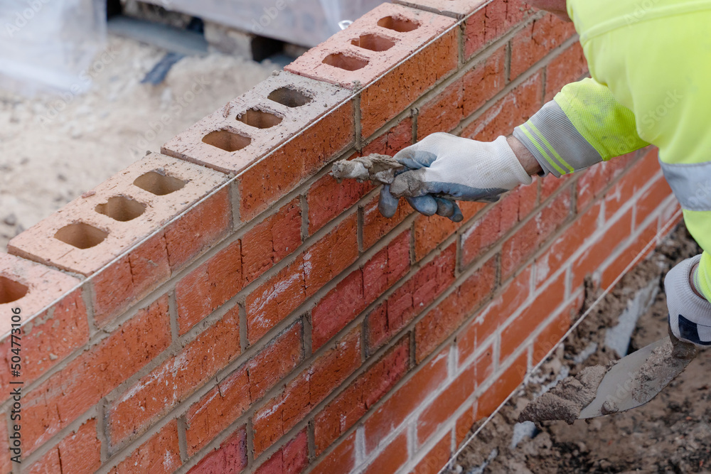 Bricklayer filling joints in the brick wall. Pointing joints in the ...