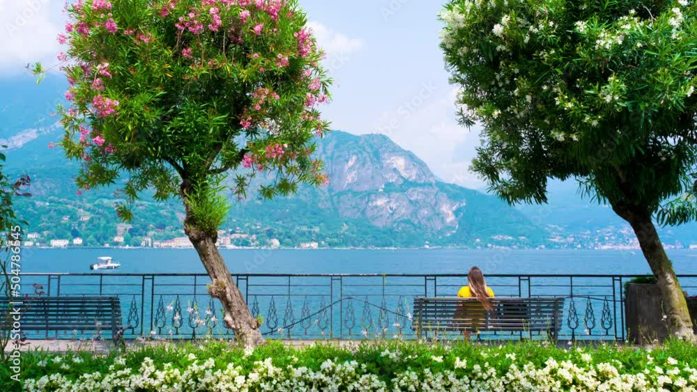 Bellagio borgo on Lake Como, Italy. Beautiful girl sits in front of ...