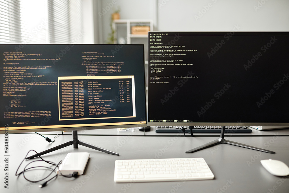 Background image of two computers on desk with code lines on screen in ...