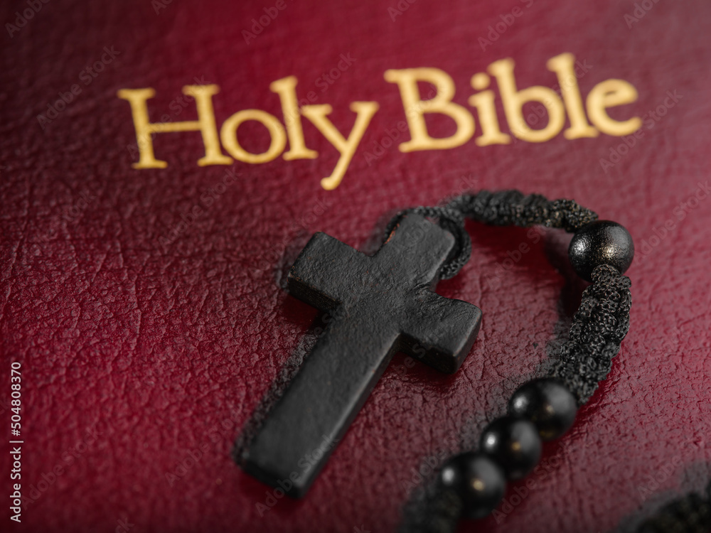 Macro shot. Red book with gold letters - the Holy Bible and an old ...