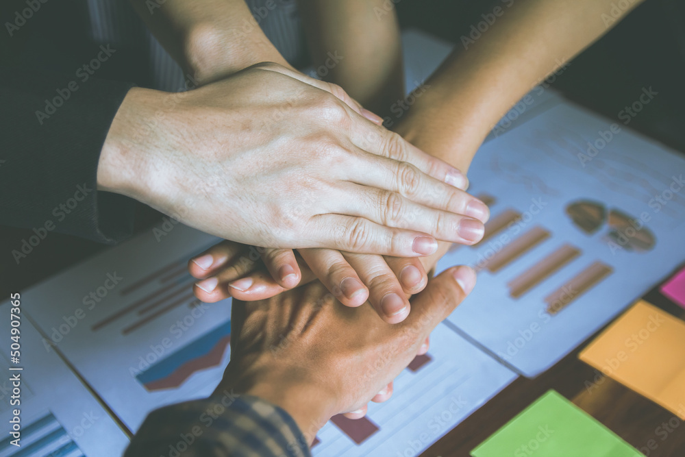 Group Asian business people put their hands together. Stacking hands ...