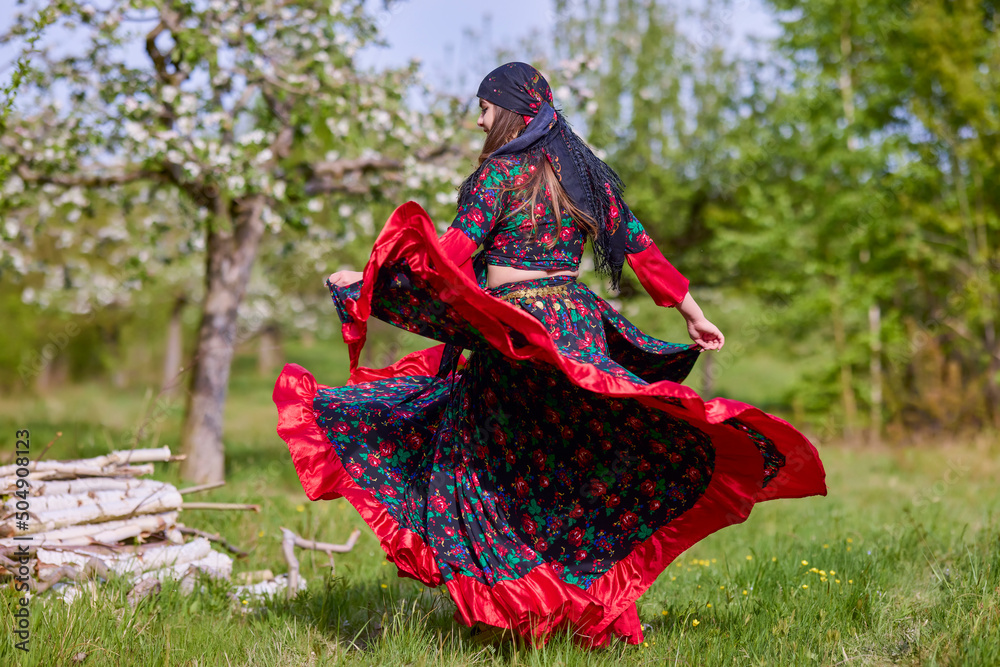 beautiful woman in traditional gypsy dress posing in nature in spring ...