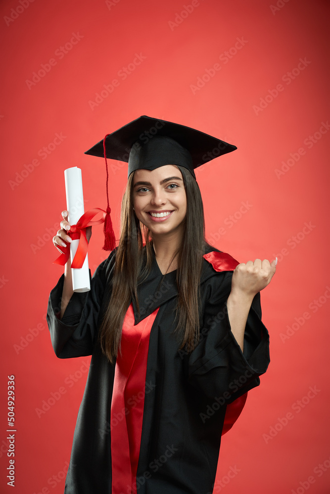 Front view of pretty girl in graduate gown and mortarboard graduaing ...