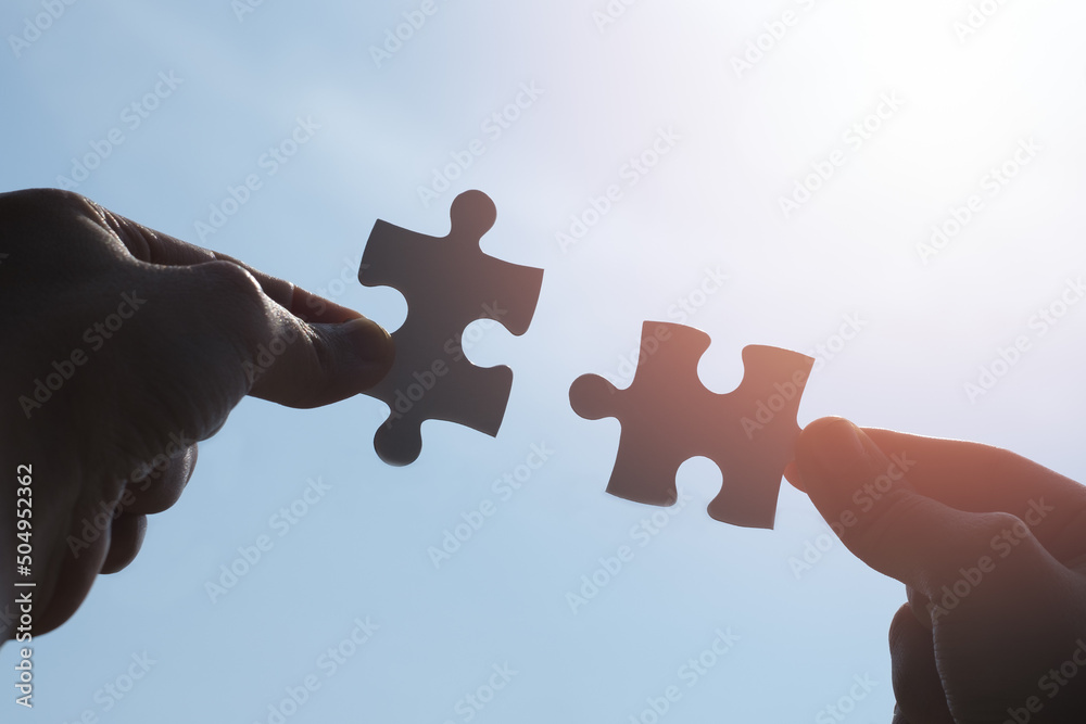 two hands trying to connect couple puzzle piece with sky sunset ...