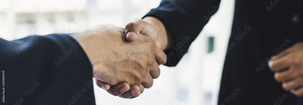 Greeting and meeting, business partners as partners shaking hands to ...