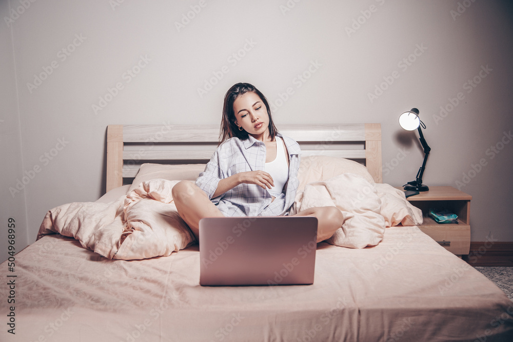 a young Asian webcam model girl is sitting in front of a laptop with ...