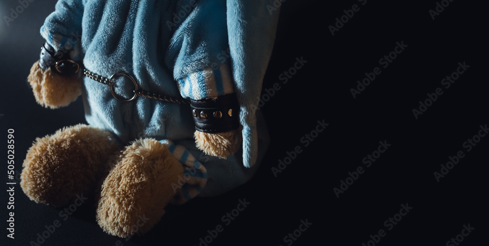 Poster Toy bear is kneeling, facing the wall, hands behind his back in ...