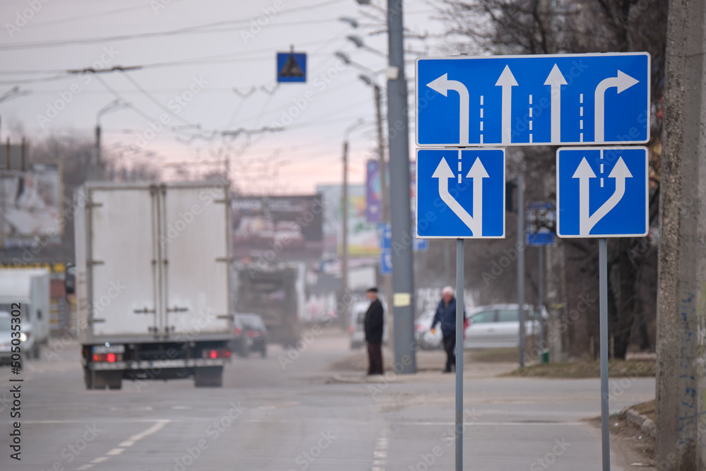 Traffic sign pointing multiple road lanes direction on city street ...