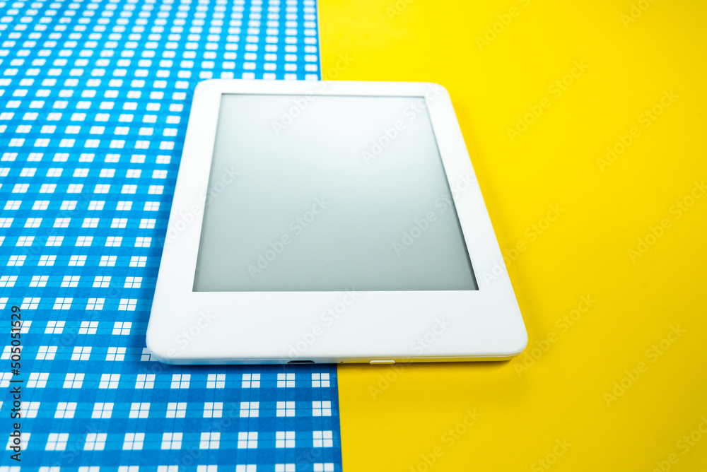Ebook reader over yellow and blue background Stock Photo | Adobe Stock
