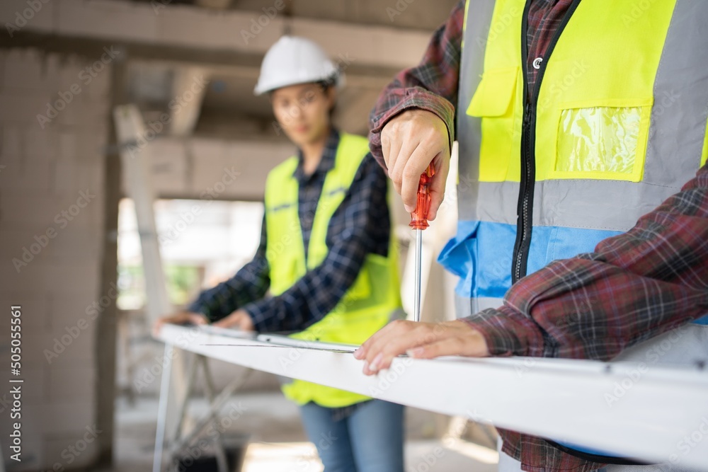 Asian Handyman in engineer uniform installs new window by using hand ...